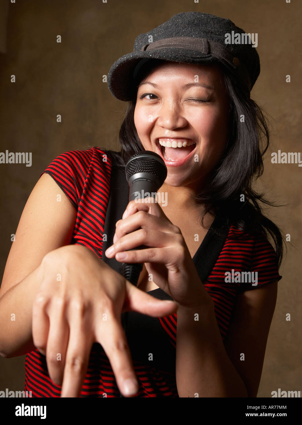 Asian woman singing with microphone Stock Photo - Alamy