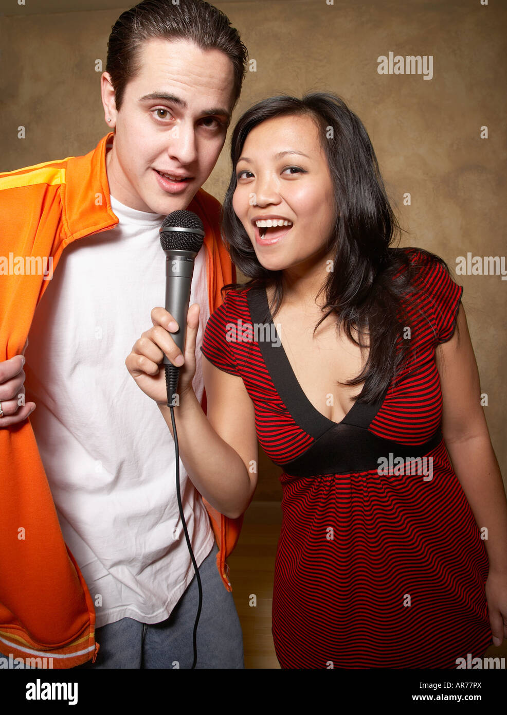 Multi-ethnic friends singing with microphone Stock Photo - Alamy