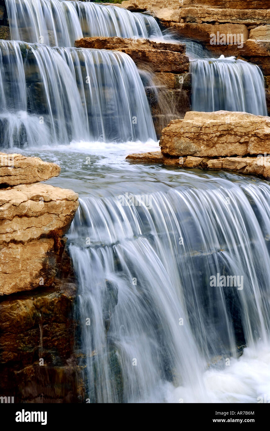 Beautiful cascading waterfall over natural rocks landscaping element ...