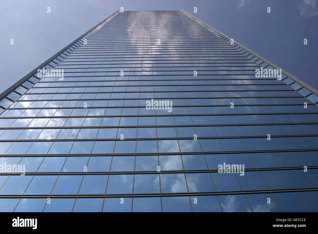 Clouds reflected in the towering side of a modern high rise skyscraper ...