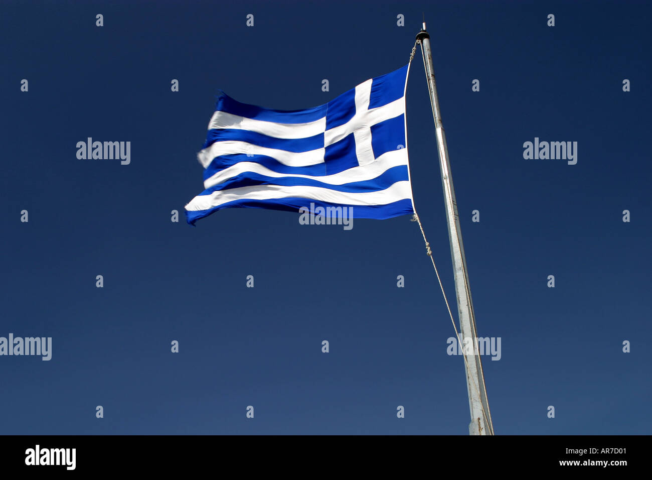 The Greek flag flying at the Acropolis Athens Greece against a dark ...