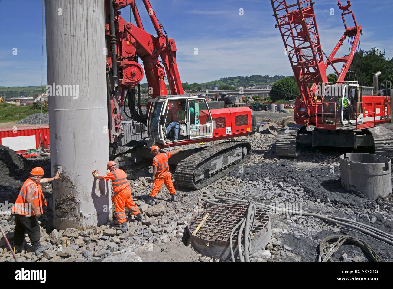 Workers install temporary piling support casing. A network of ...