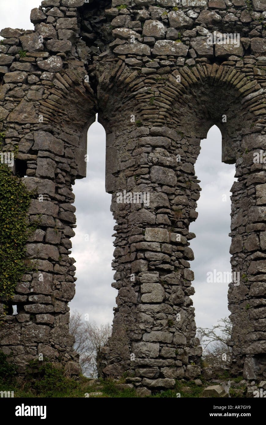 Dry stone brickwork of two oval arched windows in a ruined church ...