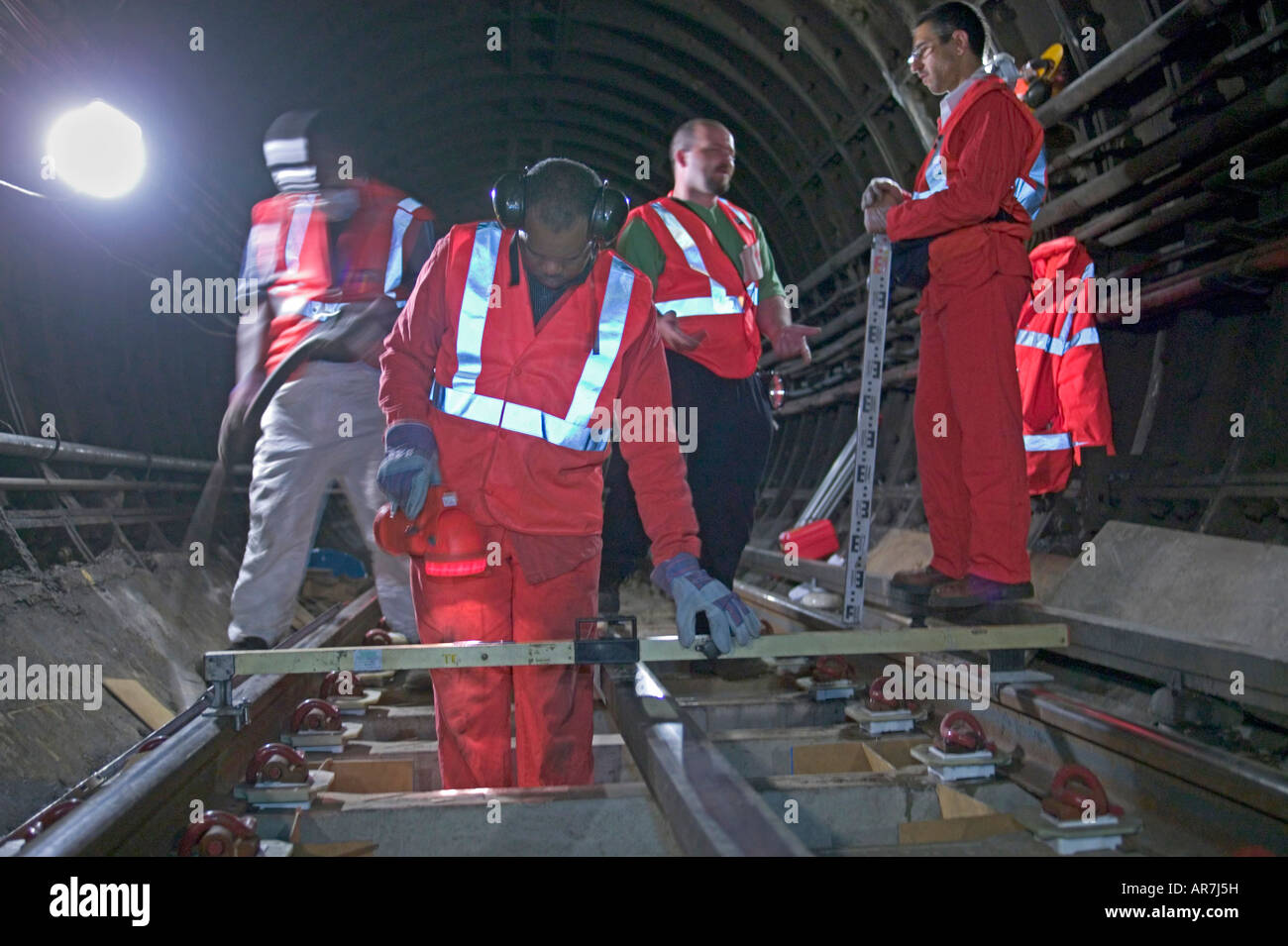 London Underground engineer checks the alignment of a section of ...