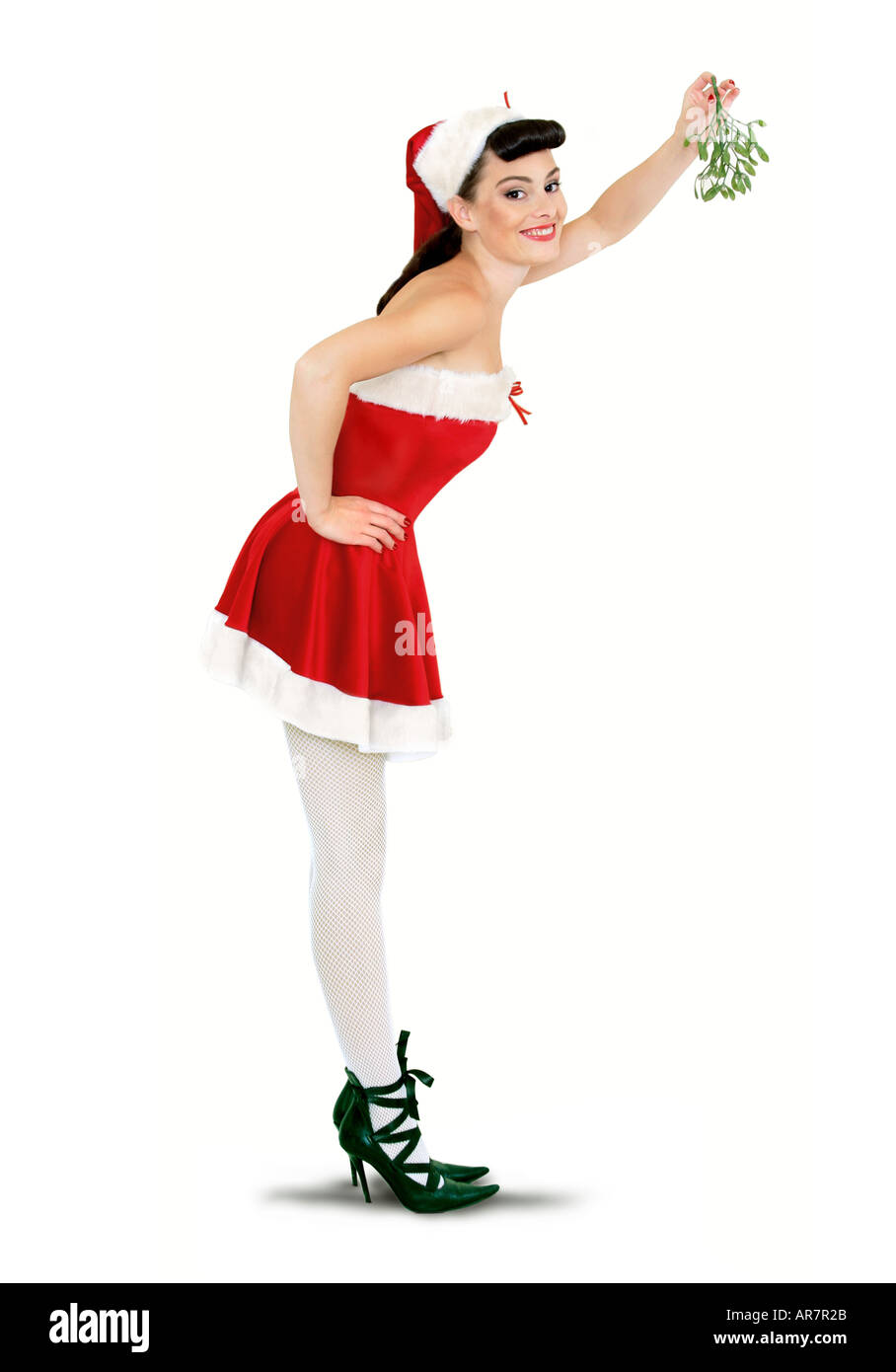 Pin up style sexy Santa holding mistletoe and smiling Stock Photo - Alamy