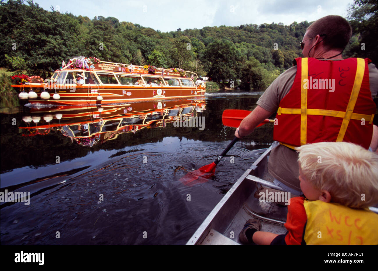 Canoeists and pleasure sightseeing boats on the River Wye at Symonds ...