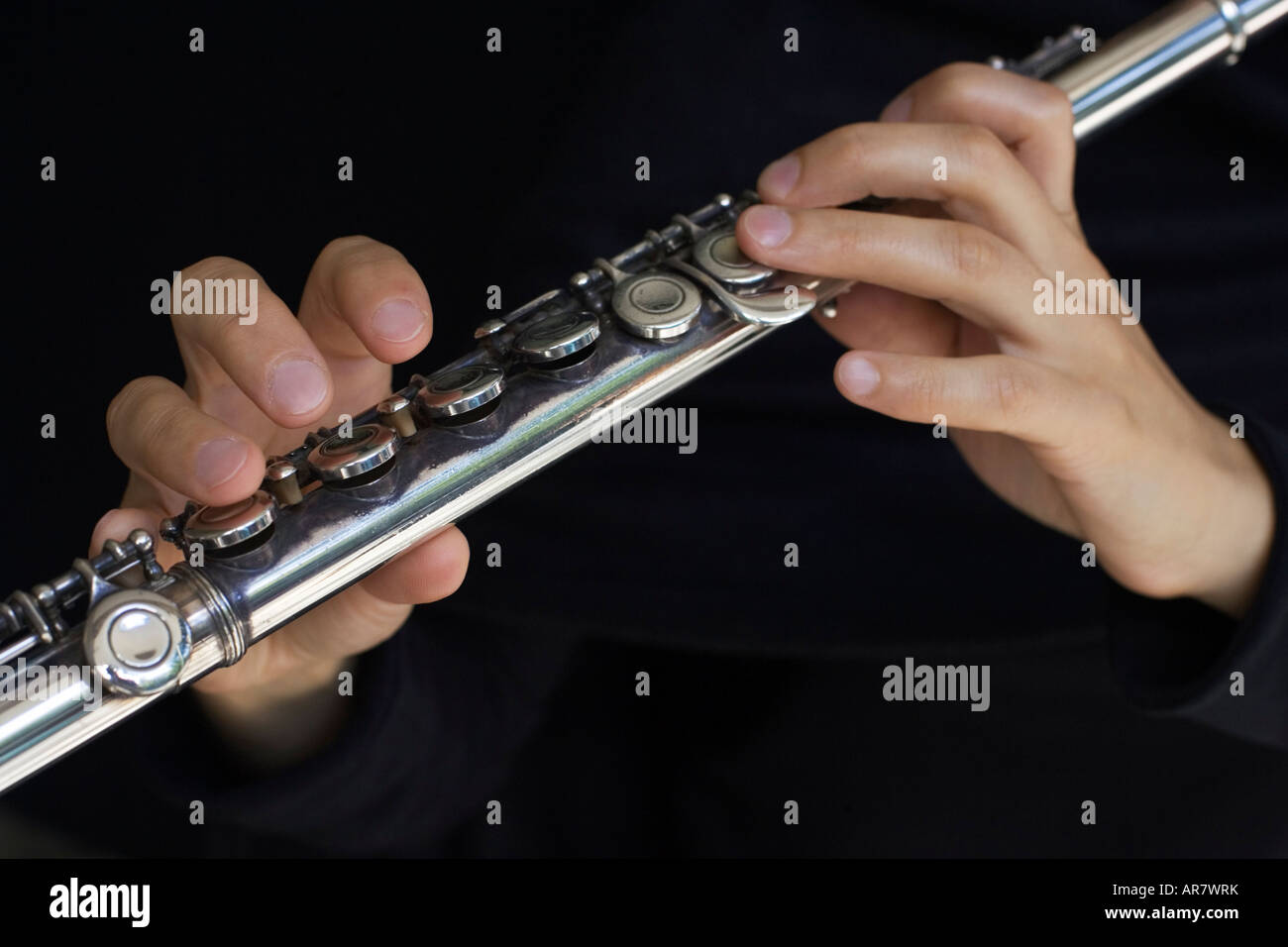 Flute player hands in a black background Stock Photo - Alamy