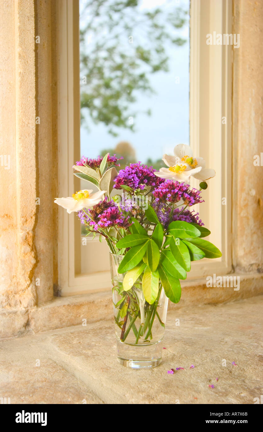 A colourful vase of flowers on a stone window sill Stock Photo - Alamy