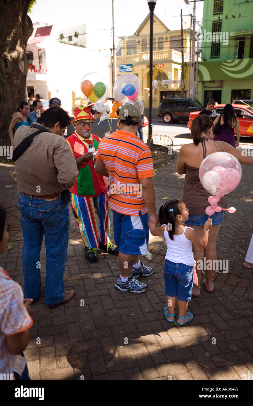 Costa Rica Alajuela Parque Central crowd around clown selling balloons ...