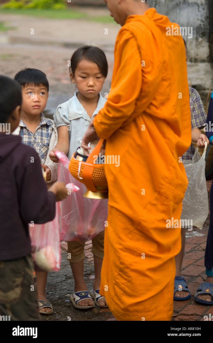 Monk giving alms to children in Luang Prabang, Laos Stock Photo - Alamy