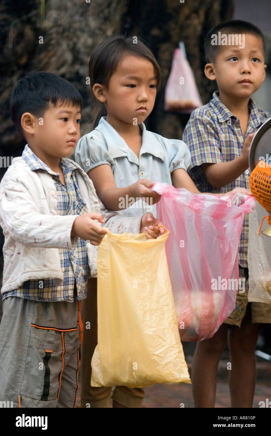 Monk giving alms to children in Luang Prabang, Laos Stock Photo - Alamy