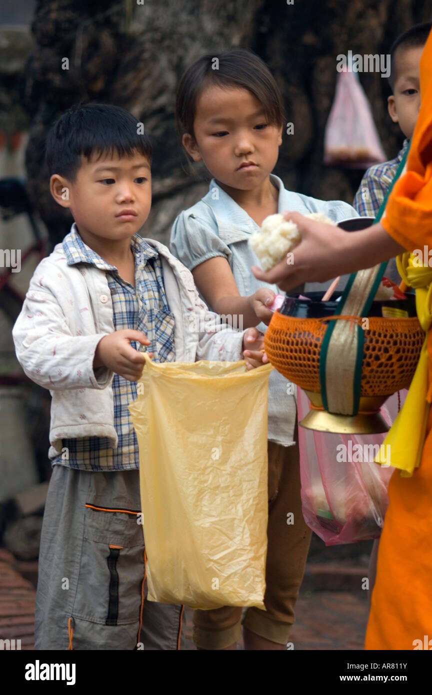 Monk giving alms to children in Luang Prabang, Laos Stock Photo - Alamy