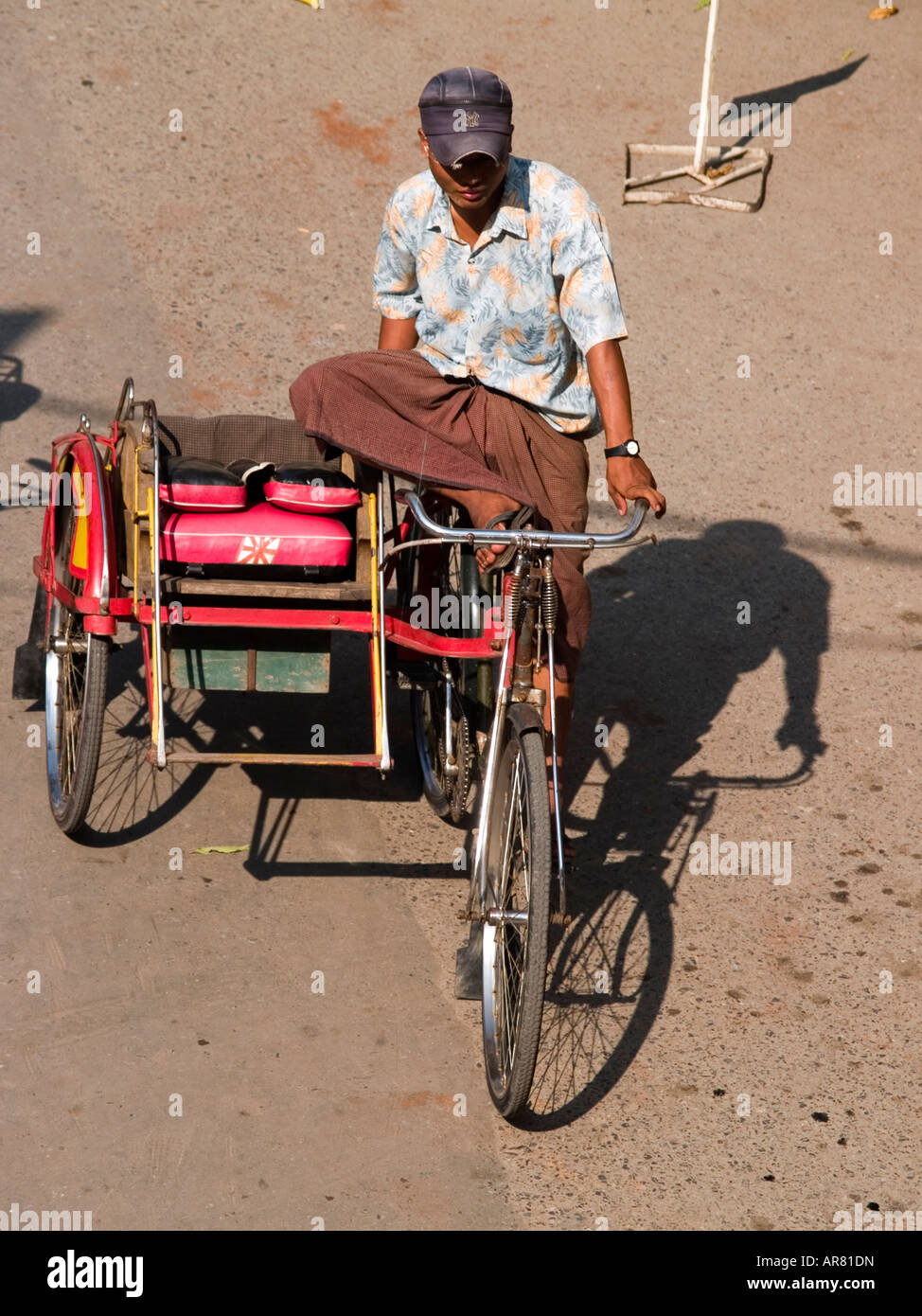 Burmese rickshaw driver pedalling Stock Photo - Alamy