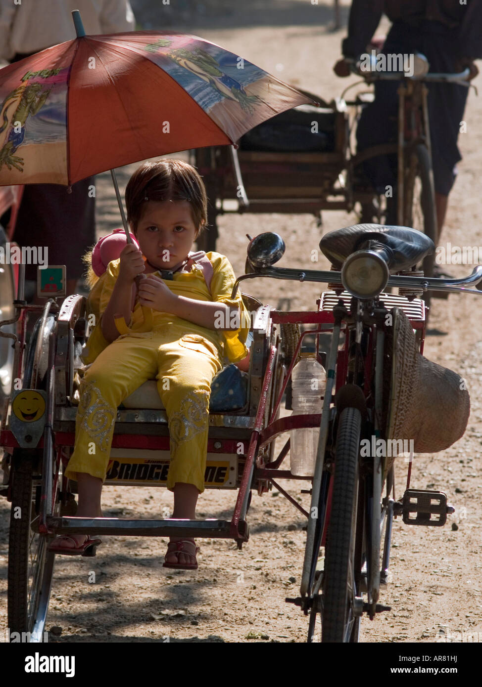 little girl under an umbrella in a rickshaw trishaw in Yangon in ...
