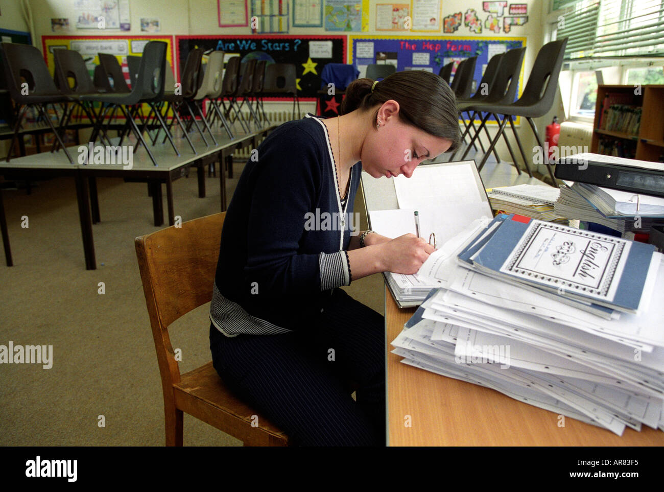 Teacher marking books after school Stock Photo - Alamy