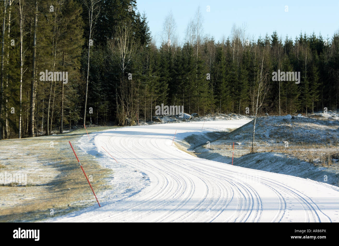 Snowy road with wheel tracks and a curve Stock Photo - Alamy