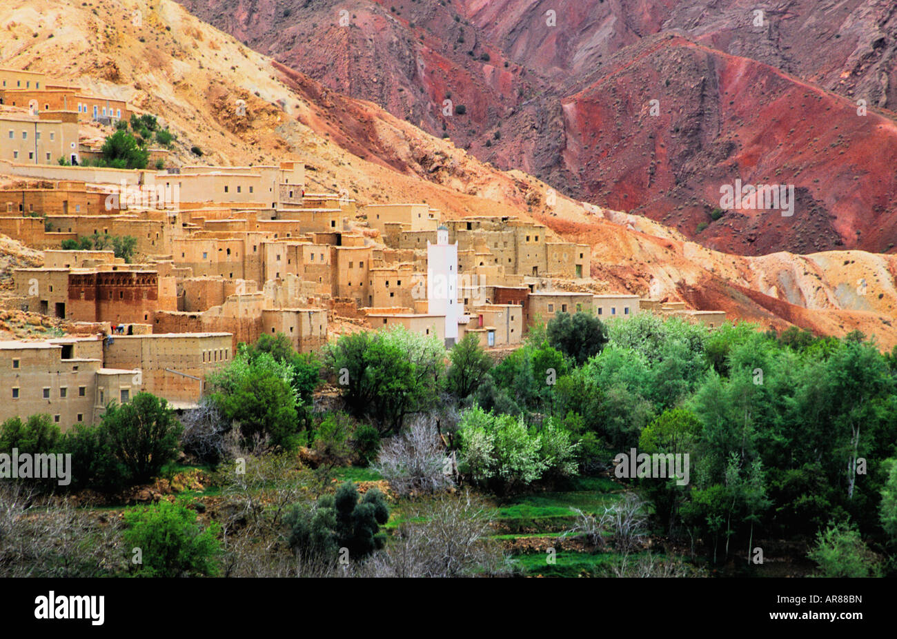 a berber village in the atlas mountains of morocco with a white minaret ...