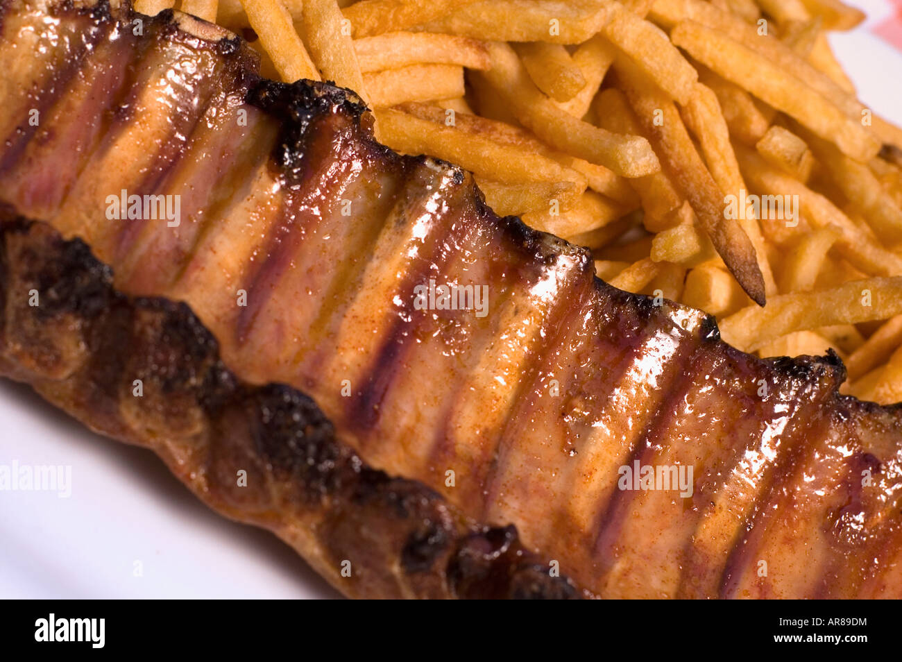 Glazed baby back ribs served with French fries Stock Photo - Alamy