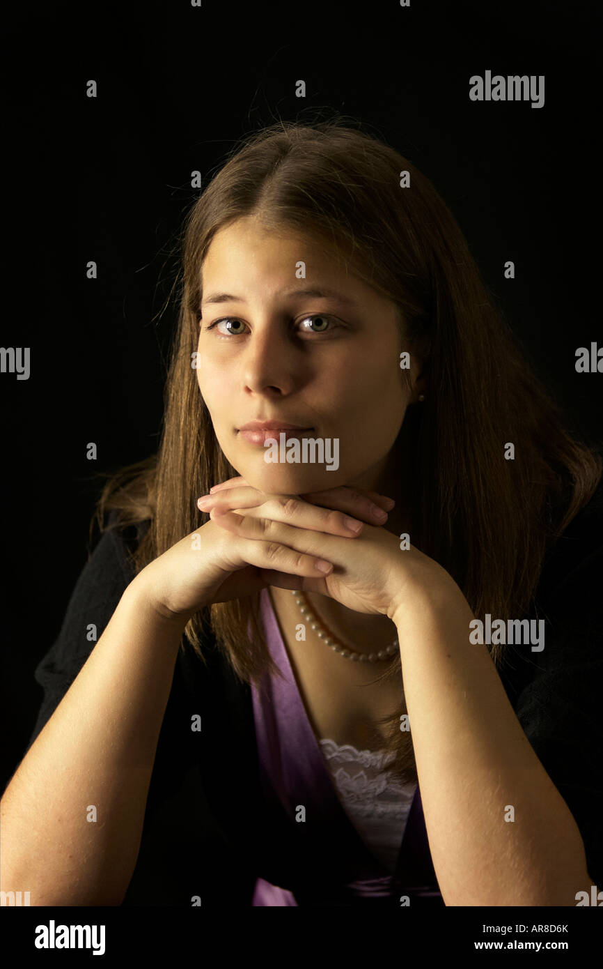 A young woman with hands resting atop her hands Stock Photo - Alamy
