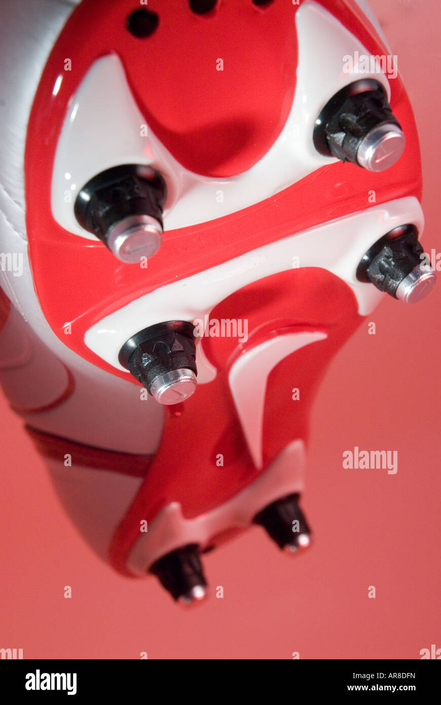 Football boot from underneath showing red and white design and studs ...