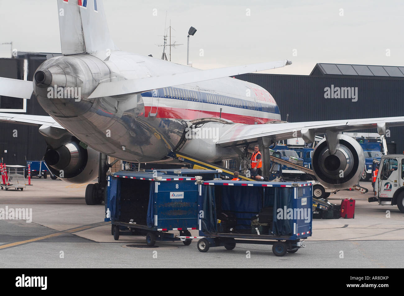 Airline baggage handlers loading suitcases on a jet Stock Photo - Alamy