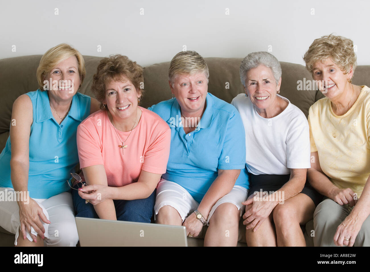 Portrait of a group of middle-aged women sitting together on a couch ...