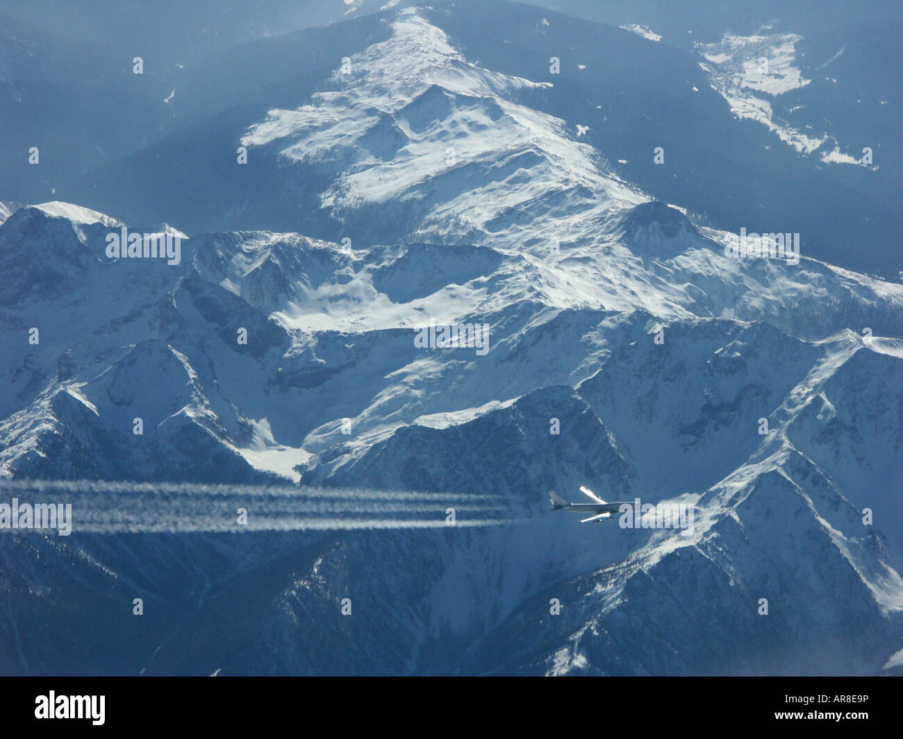 Passenger Jet flying over Mountains Stock Photo - Alamy