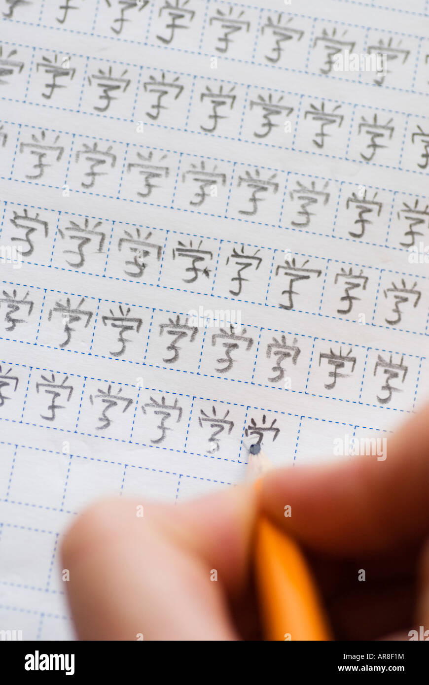 Foreign student learning to write Chinese characters by repetition with ...