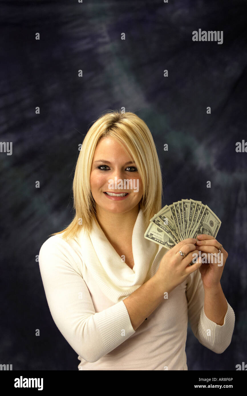 A pretty young woman smiling and holding US currency bank notes Stock ...