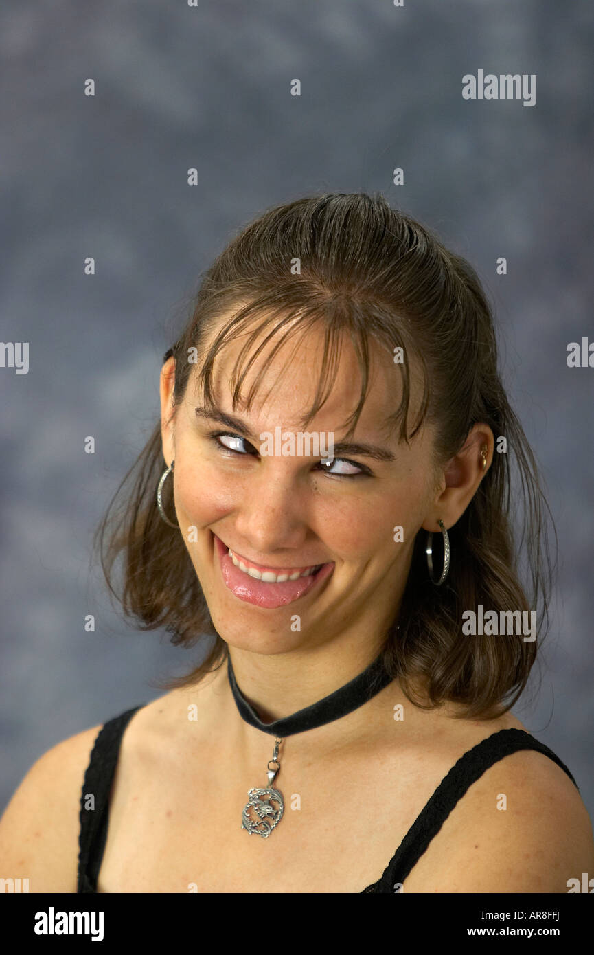 A cute young caucasian woman with eyes crossed making a silly face ...