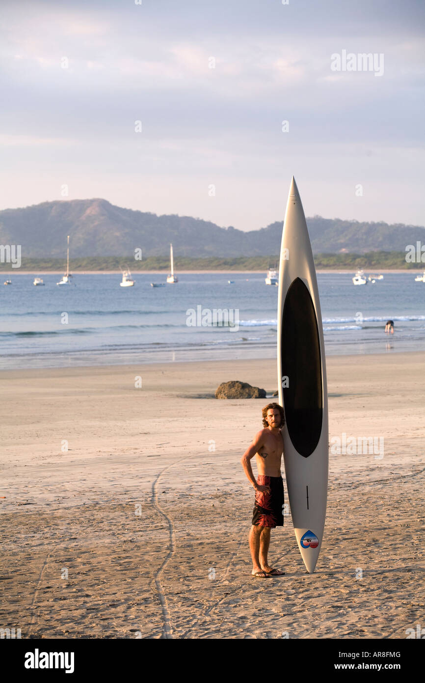 A man walks into the ocean with his stand up paddle board on Playa ...