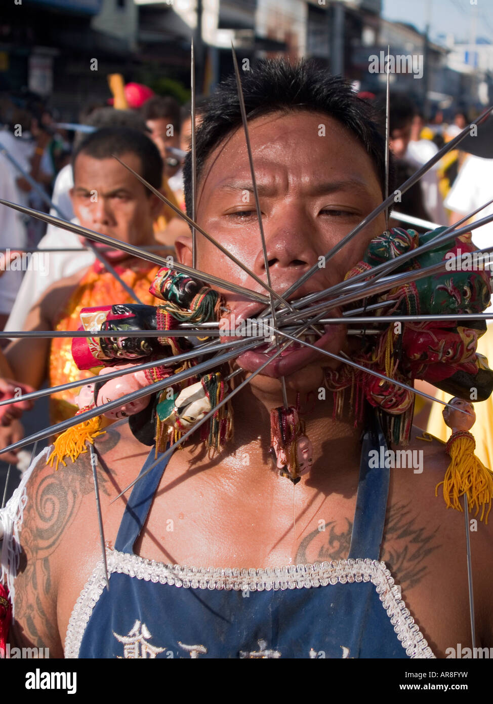 a grotesque face full of metal at the bizarre Vegetarian Festival ...