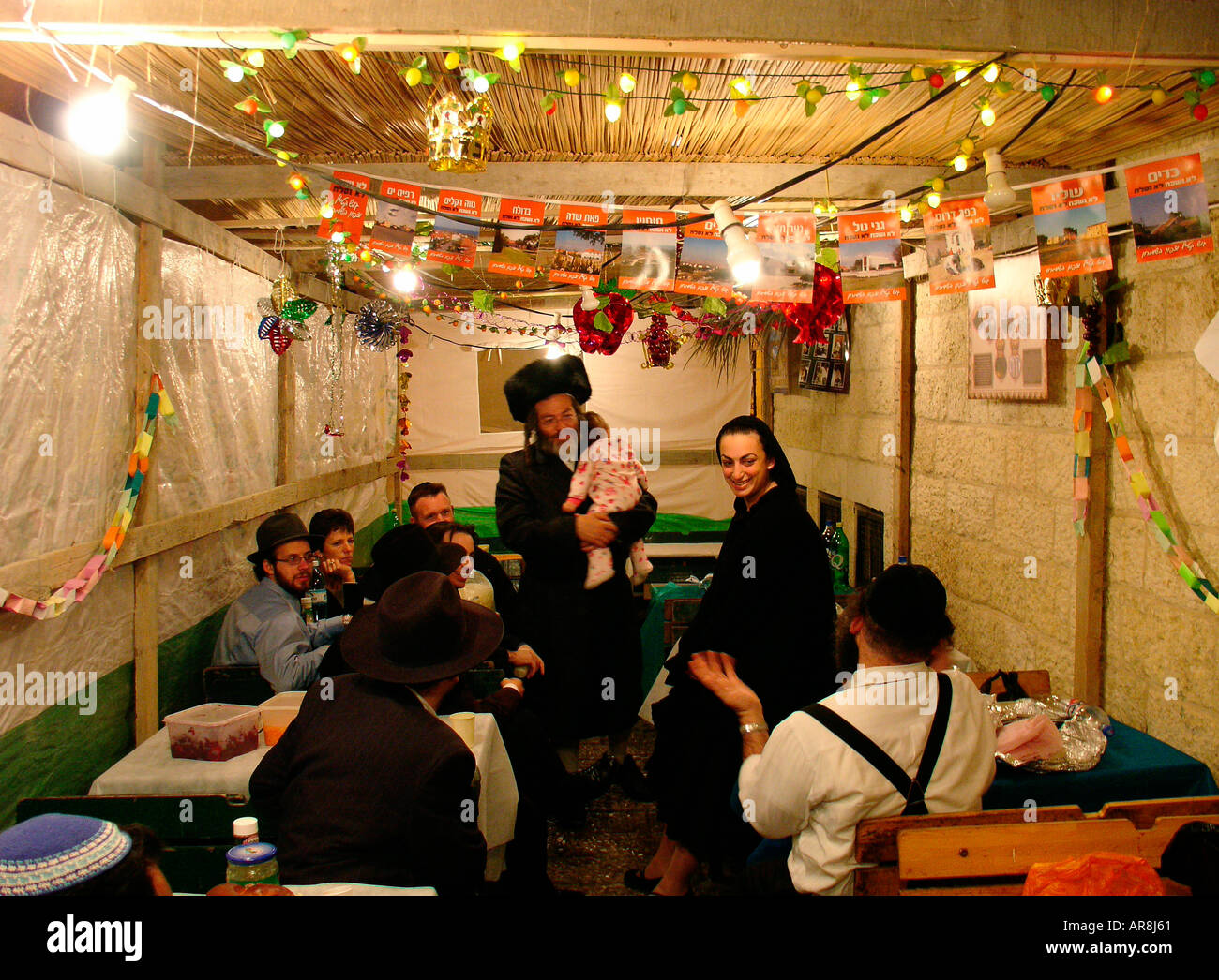 Orthodox Jews inside a traditional wooden sukkah or succah temporary ...