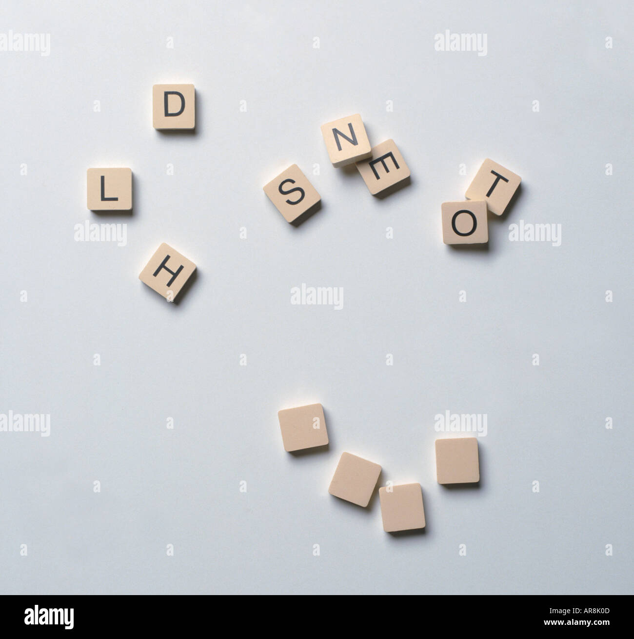 Scrabble game tiles scattered over white surface some blank tiles and ...