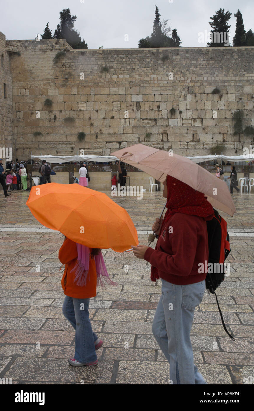 Israel Jerusalem Western Wall women and child walking with umbrellas on ...