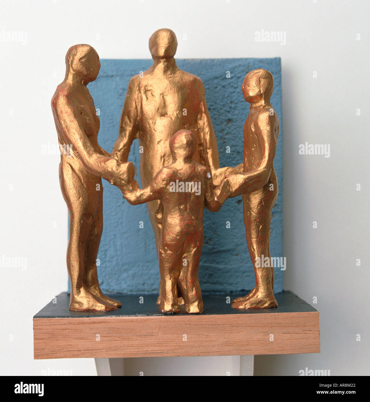 Four golden human figures of two parents and two children, standing in ...