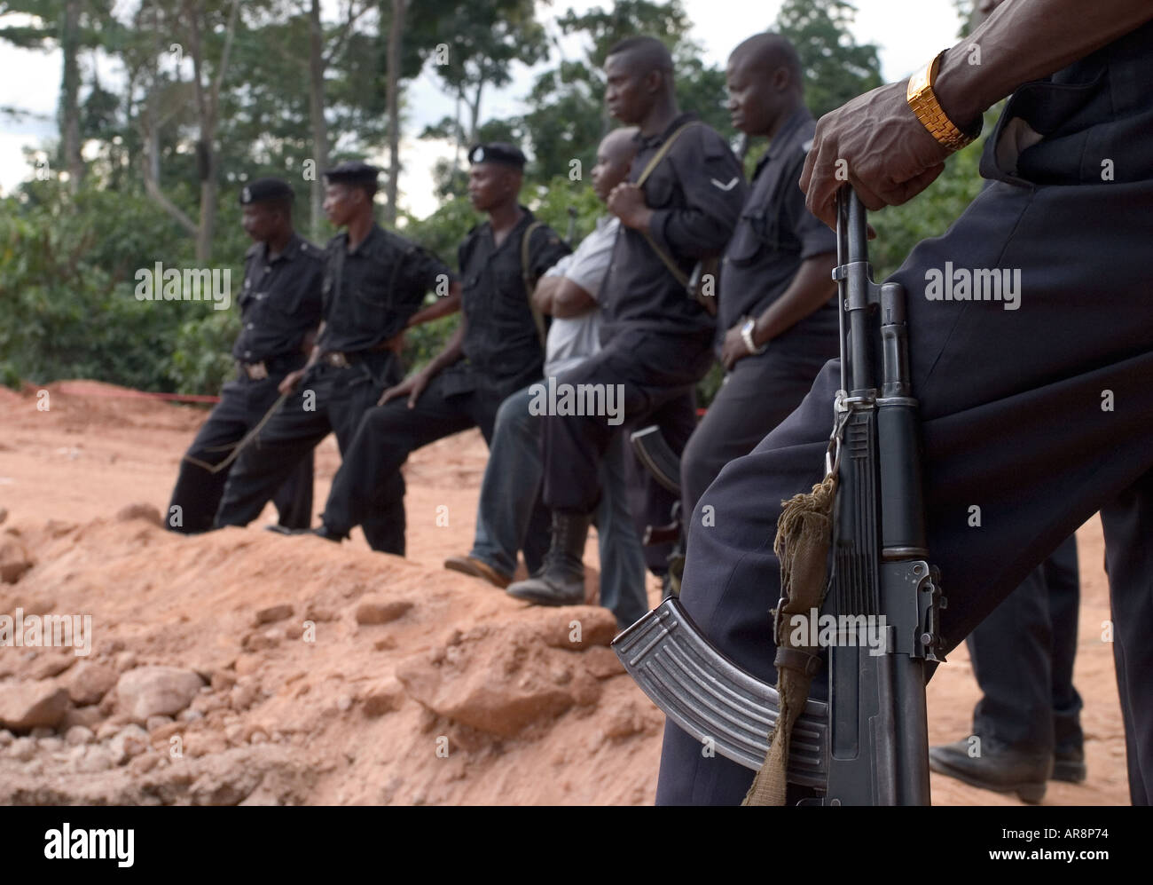 Police officers guarding gold mine pit Stock Photo - Alamy