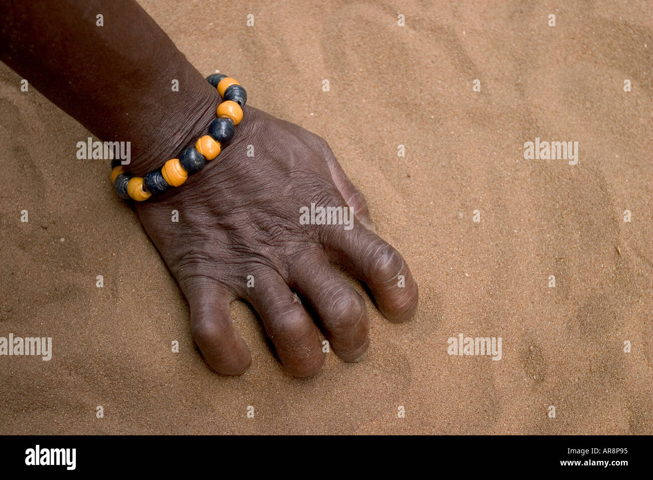 Hand wearing bracelet in sand, Ghana, Africa Stock Photo - Alamy