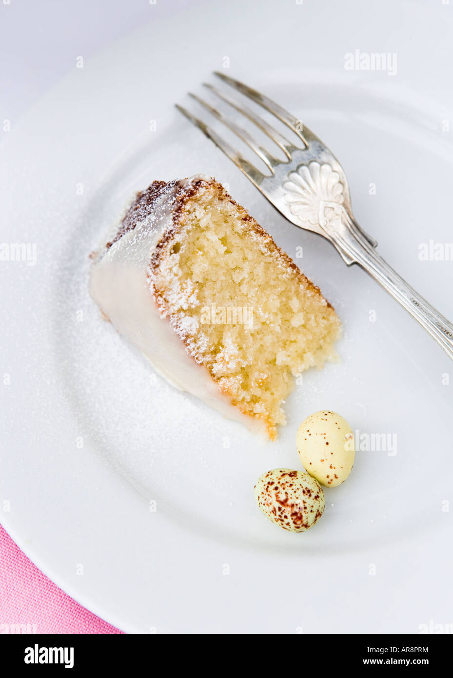 A slice of iced lemon sponge cake on a white china plate Stock Photo ...