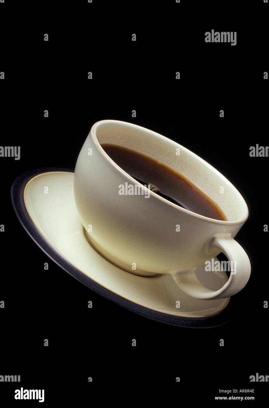 Cream coloured coffee cup and saucer on black background Stock Photo ...