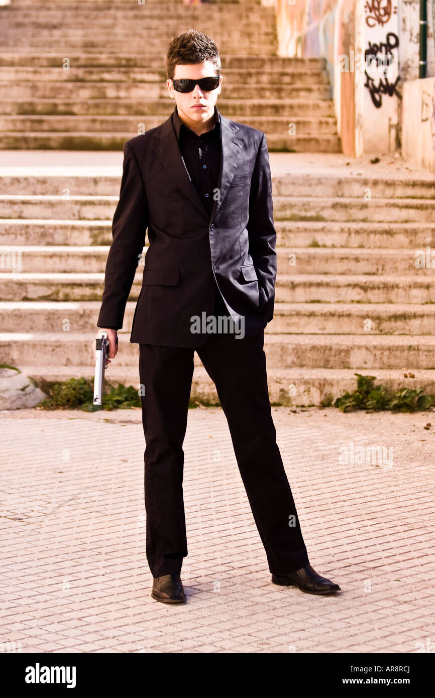 Male model performing secret agent with gun Stock Photo - Alamy