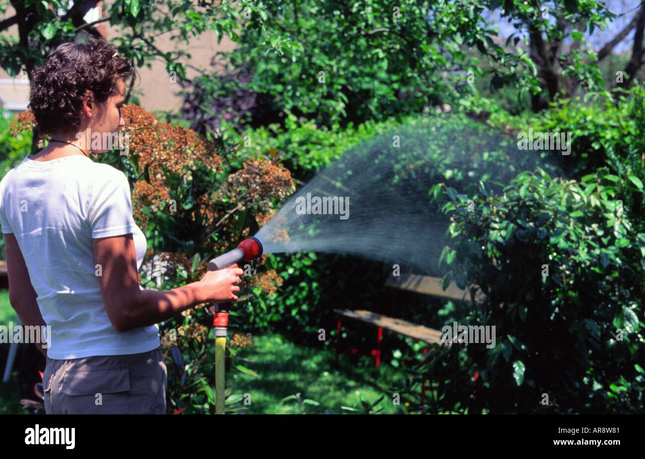 girl handing Spraying a Garden Hose Stock Photo - Alamy