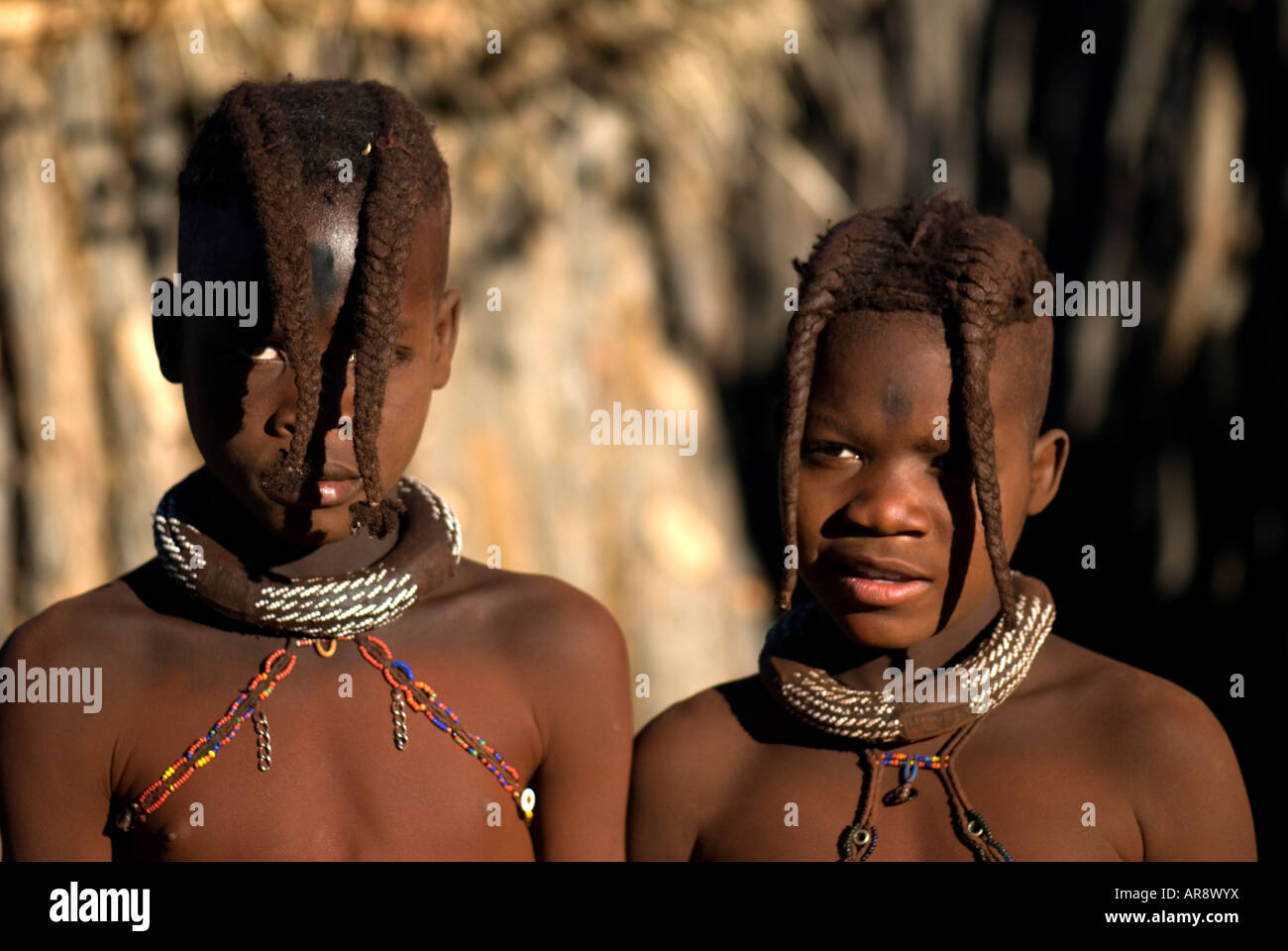 Two young Himba girls showing traditional hair style and necklace in ...