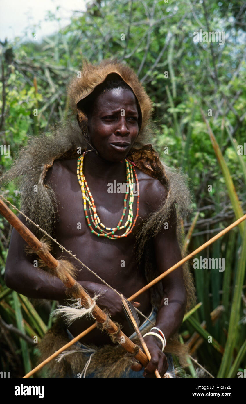 Hadzabe hunter chief wearing baboon skin head-dress and carrying home ...