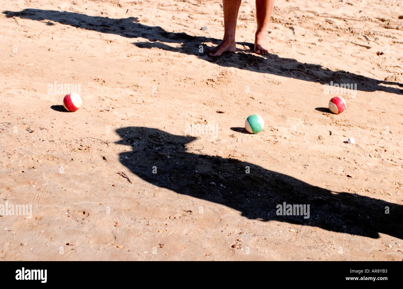 boules and shadow of player on beach in france Stock Photo - Alamy