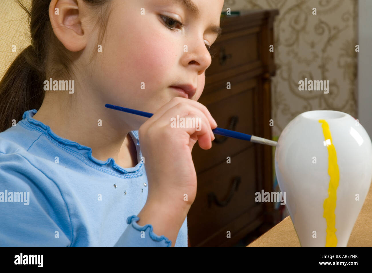 Little girl painting pottery Stock Photo - Alamy