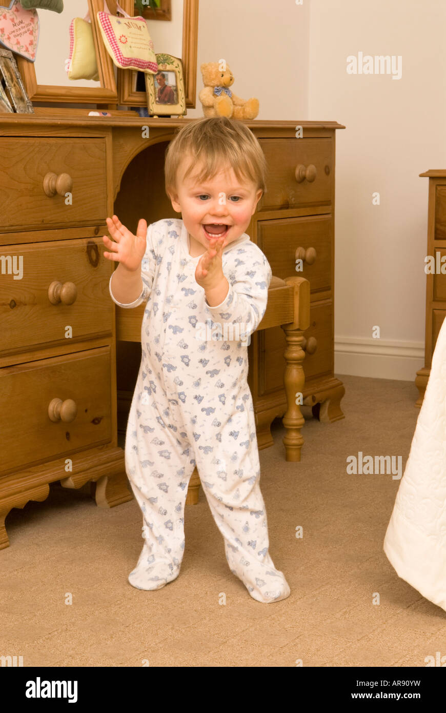 One year old baby boy toddler just taking his first steps happy smiling ...