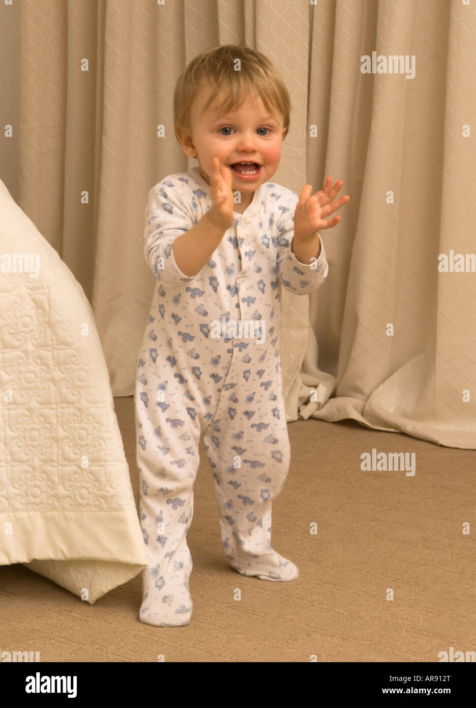 One year old baby boy toddler just taking his first steps happy smiling ...