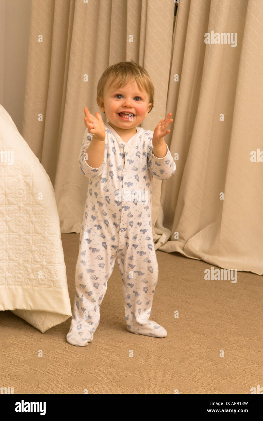 One year old baby boy toddler just taking his first steps happy smiling ...