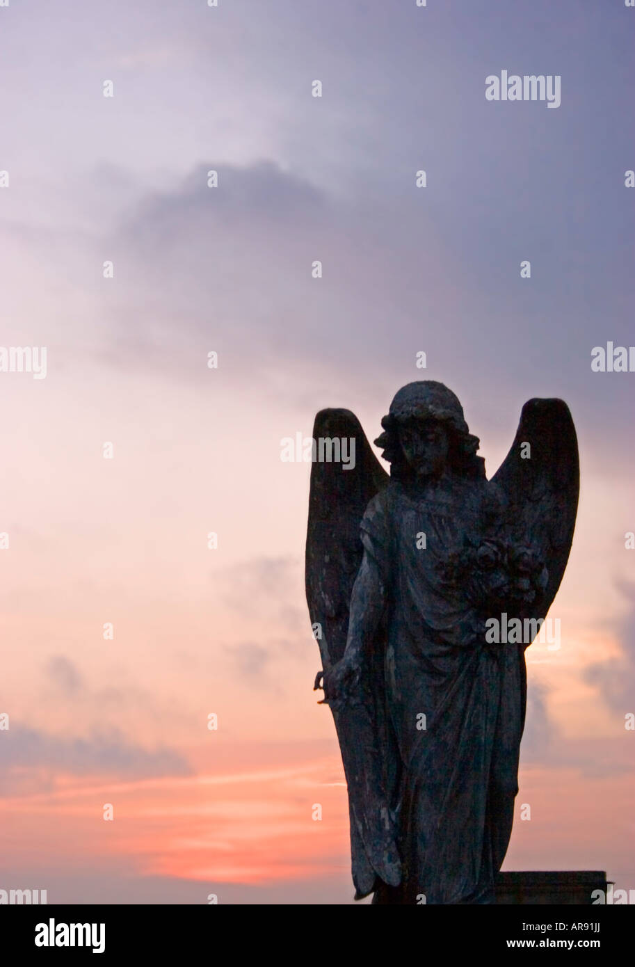 Statue of an angel silhouetted at sunset Stock Photo - Alamy